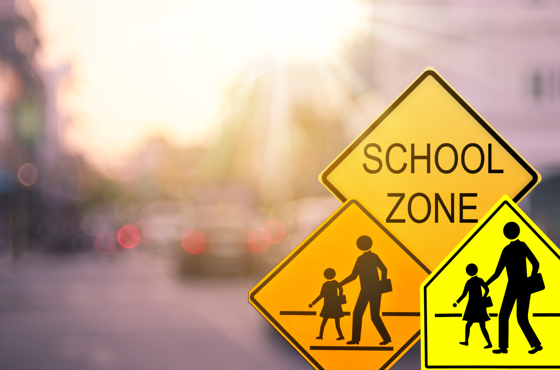 School zone warning sign on blur traffic road with colorful bokeh light ...